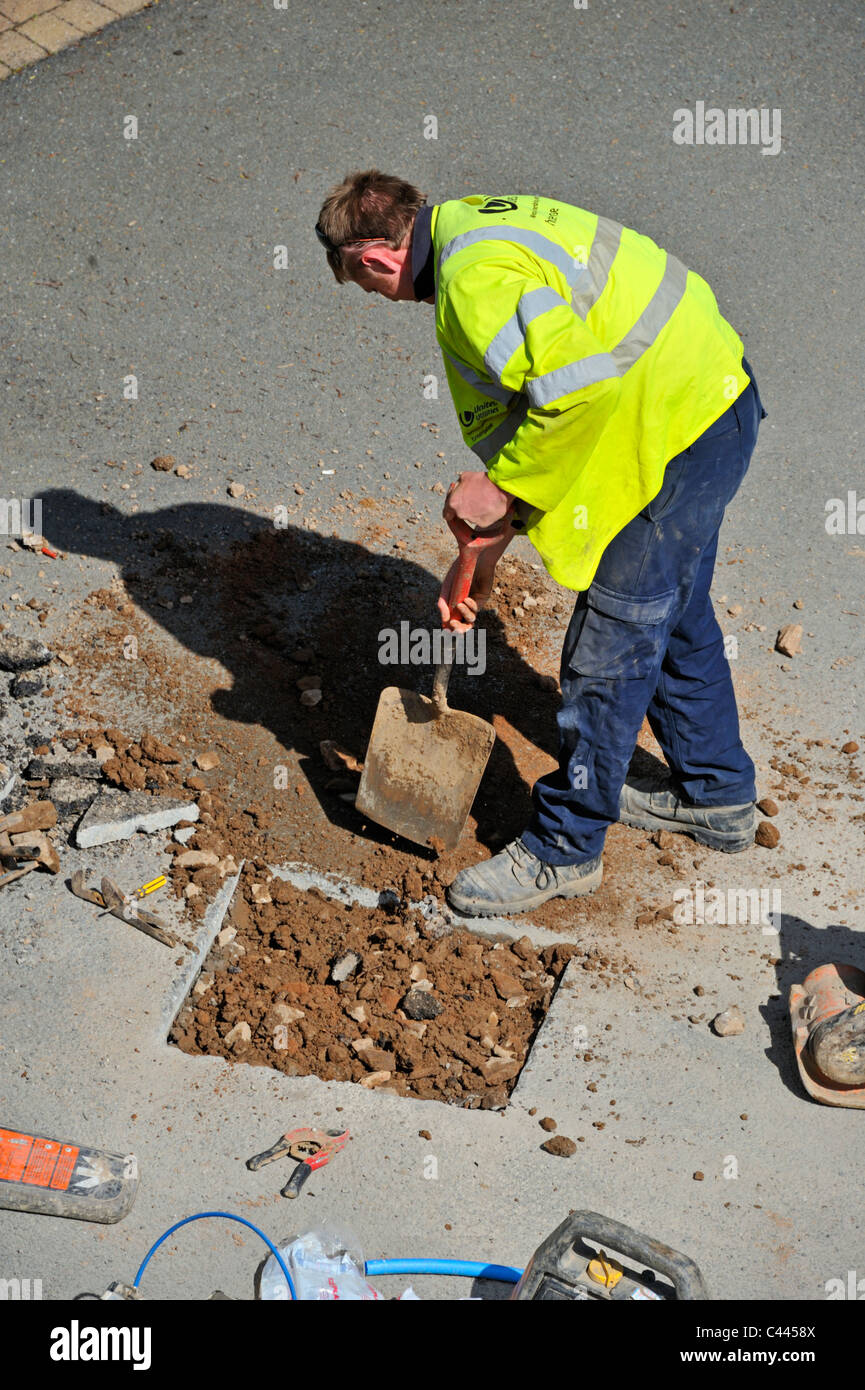 United Utilities operative backfilling excavation after investigating ...