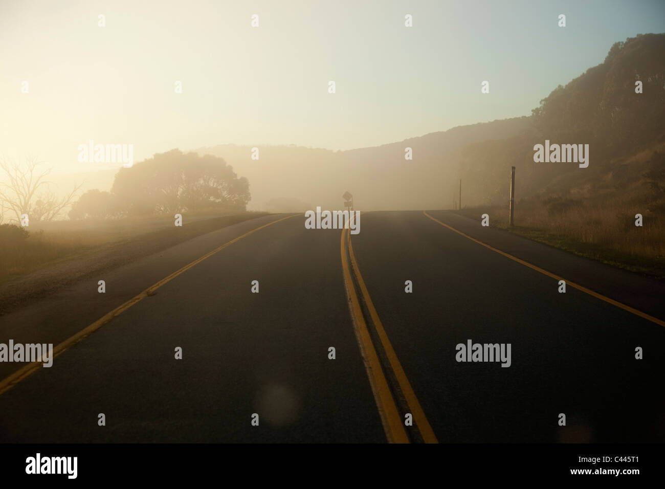 Sunlight and mist over a highway road Stock Photo - Alamy