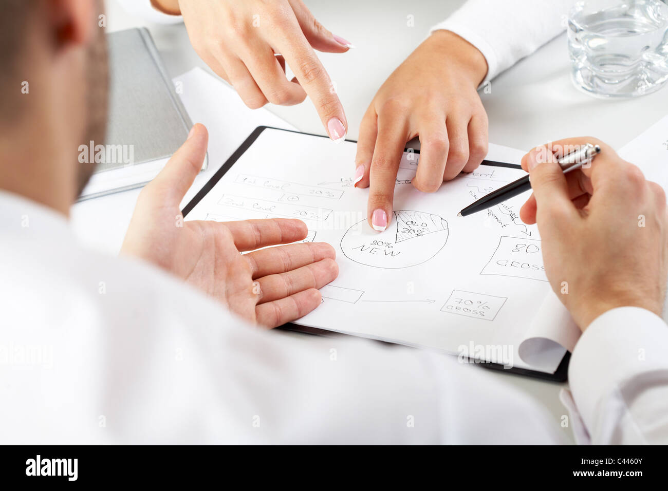Close-up of team working with documents at business meeting Stock Photo ...
