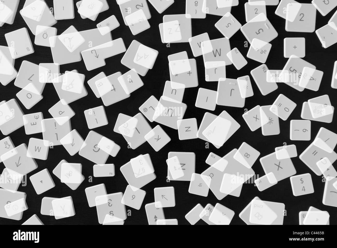 A large group of transparent computer keys scattered on a black ...