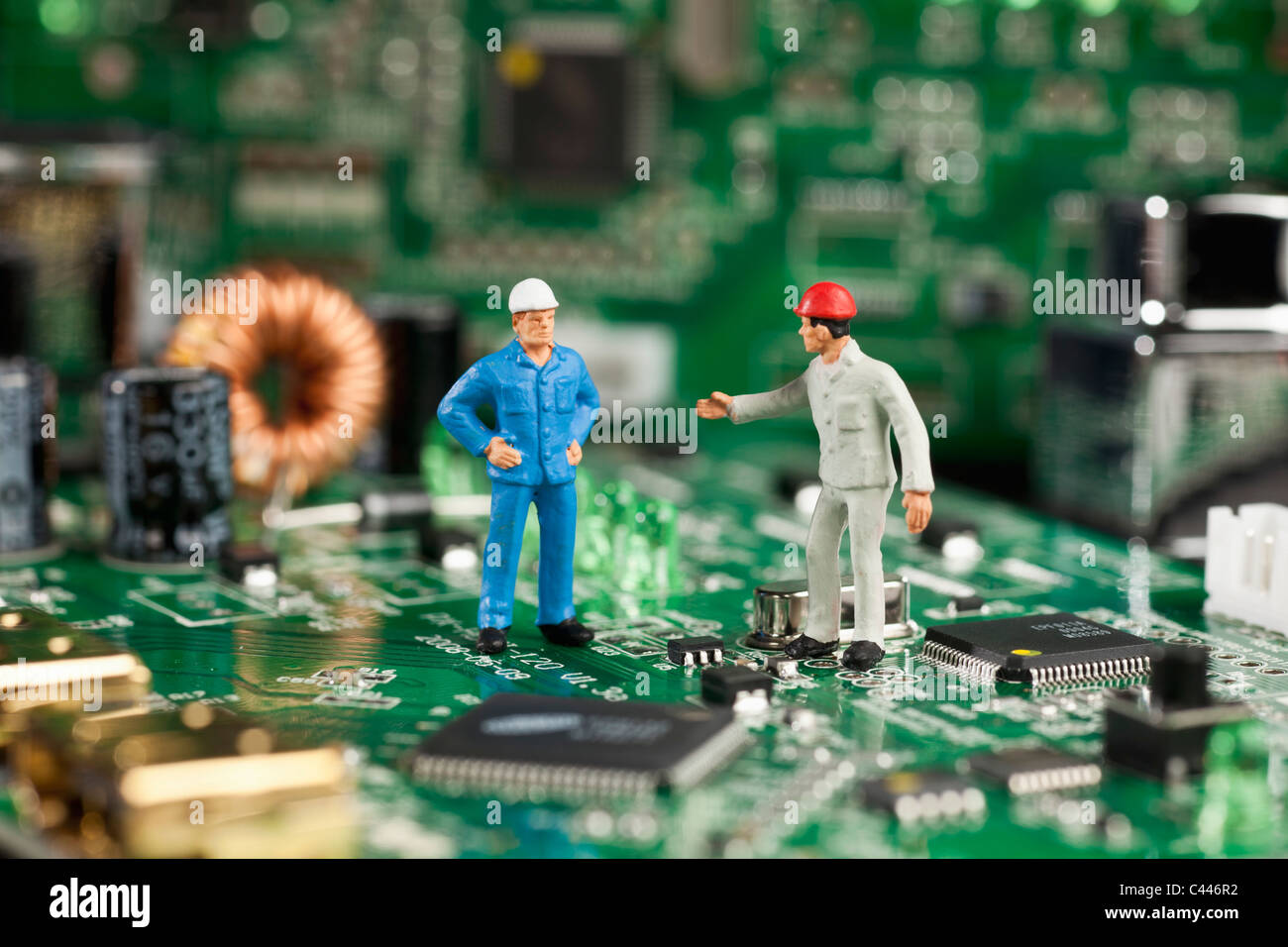 Two miniature figurine men working on a computer mother board Stock ...