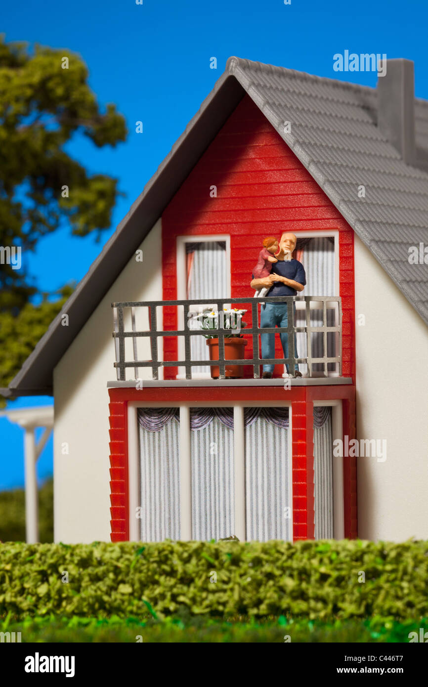 A miniature father figurine holding his daughter on the balcony of a ...