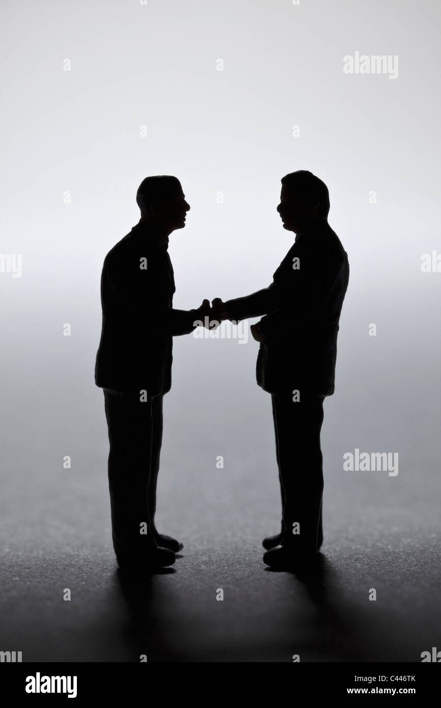 Two miniature businessmen figurines shaking hands Stock Photo - Alamy