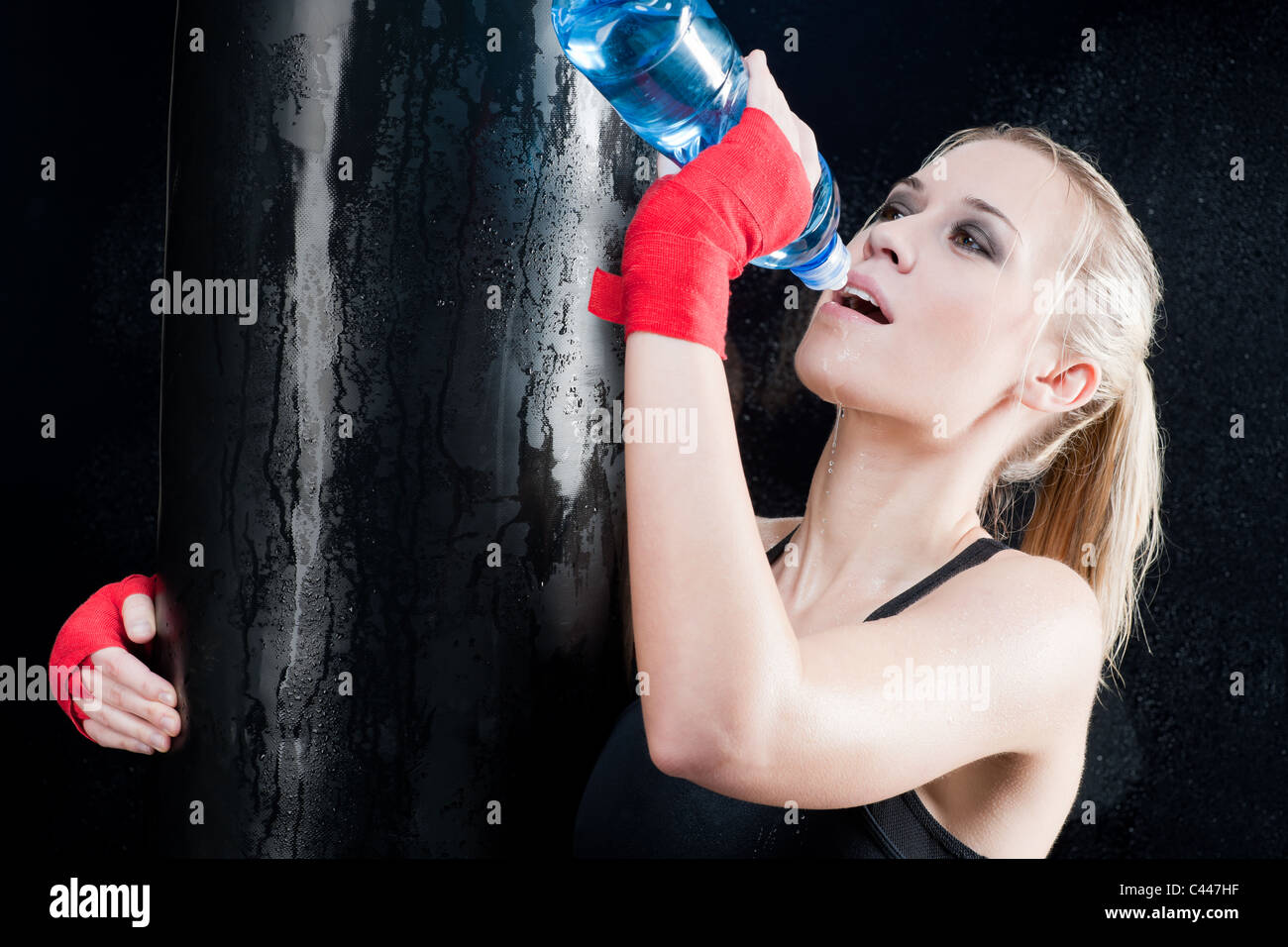 Boxing training woman drink water hold punching bag Stock Photo - Alamy