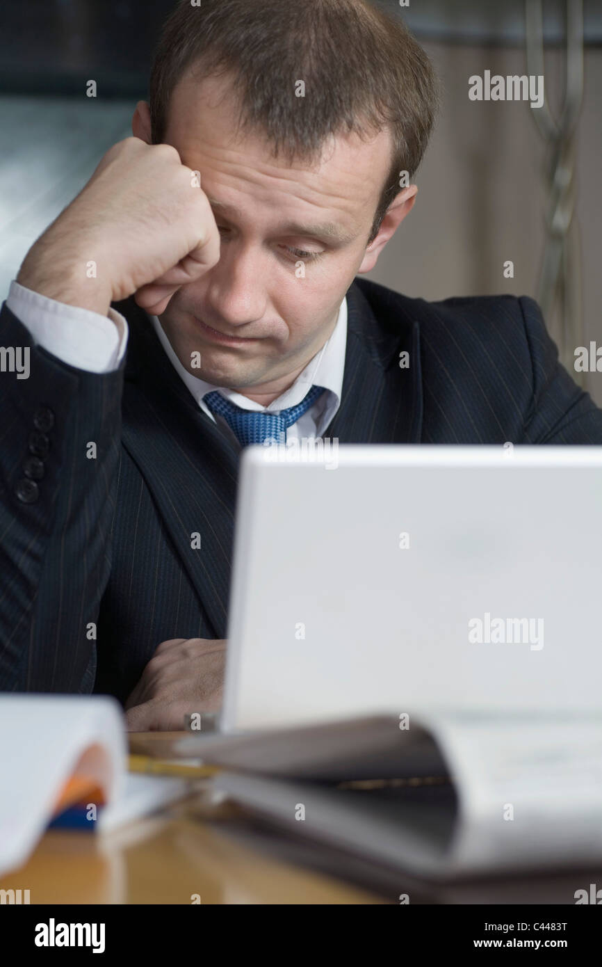 A tired businessman working late Stock Photo - Alamy