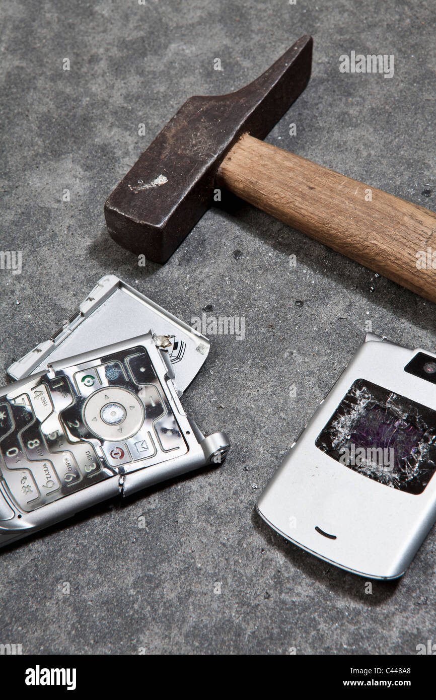 A smashed mobile phone and hammer Stock Photo - Alamy