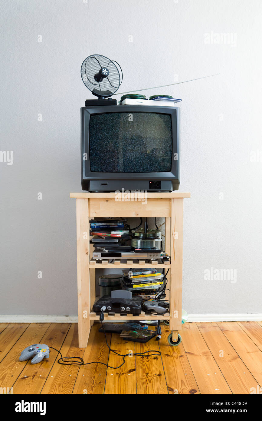 A television set on a cabinet with lots of DVDs and video games Stock ...