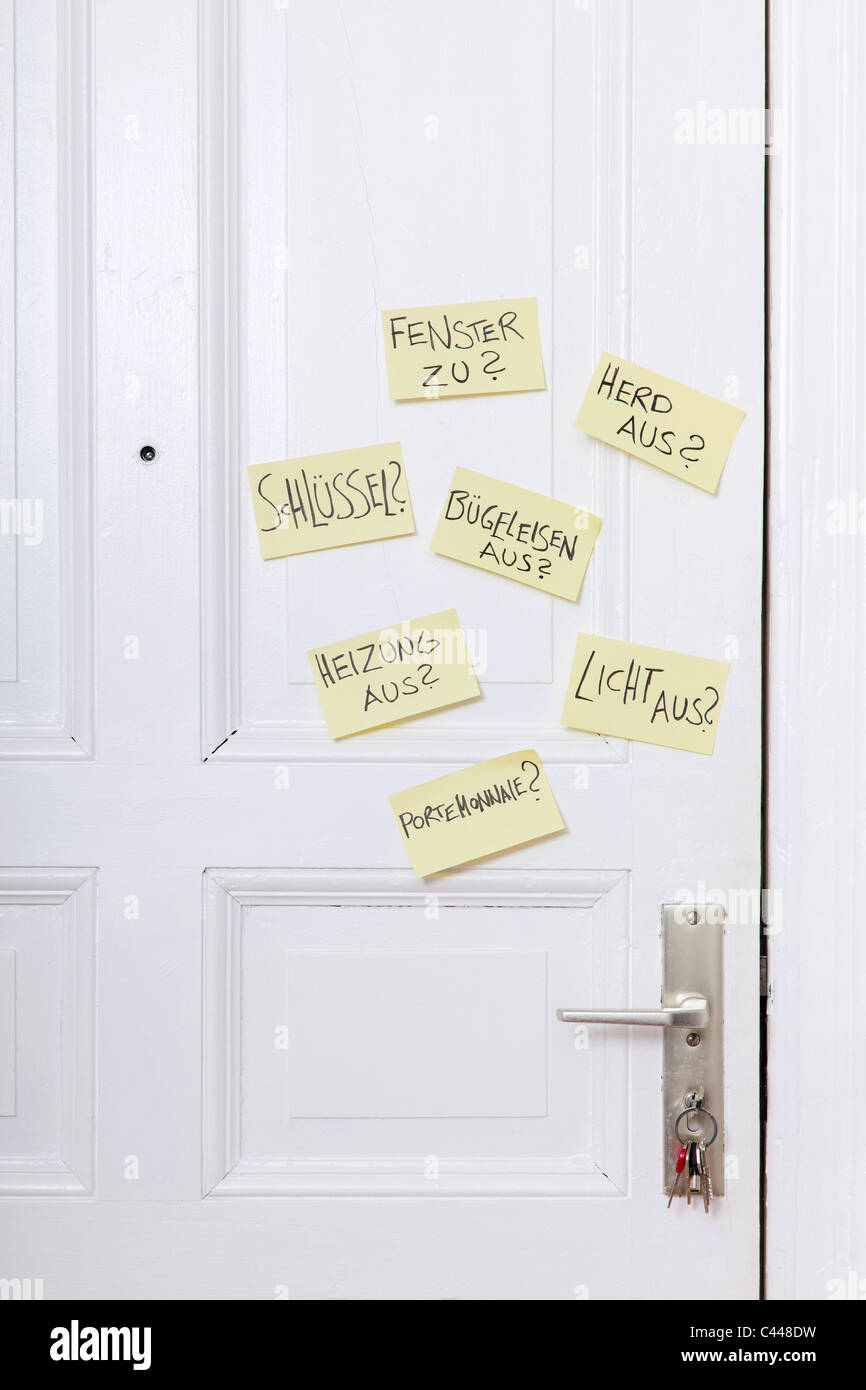 Adhesive notes on a front door with various reminders in German Stock ...