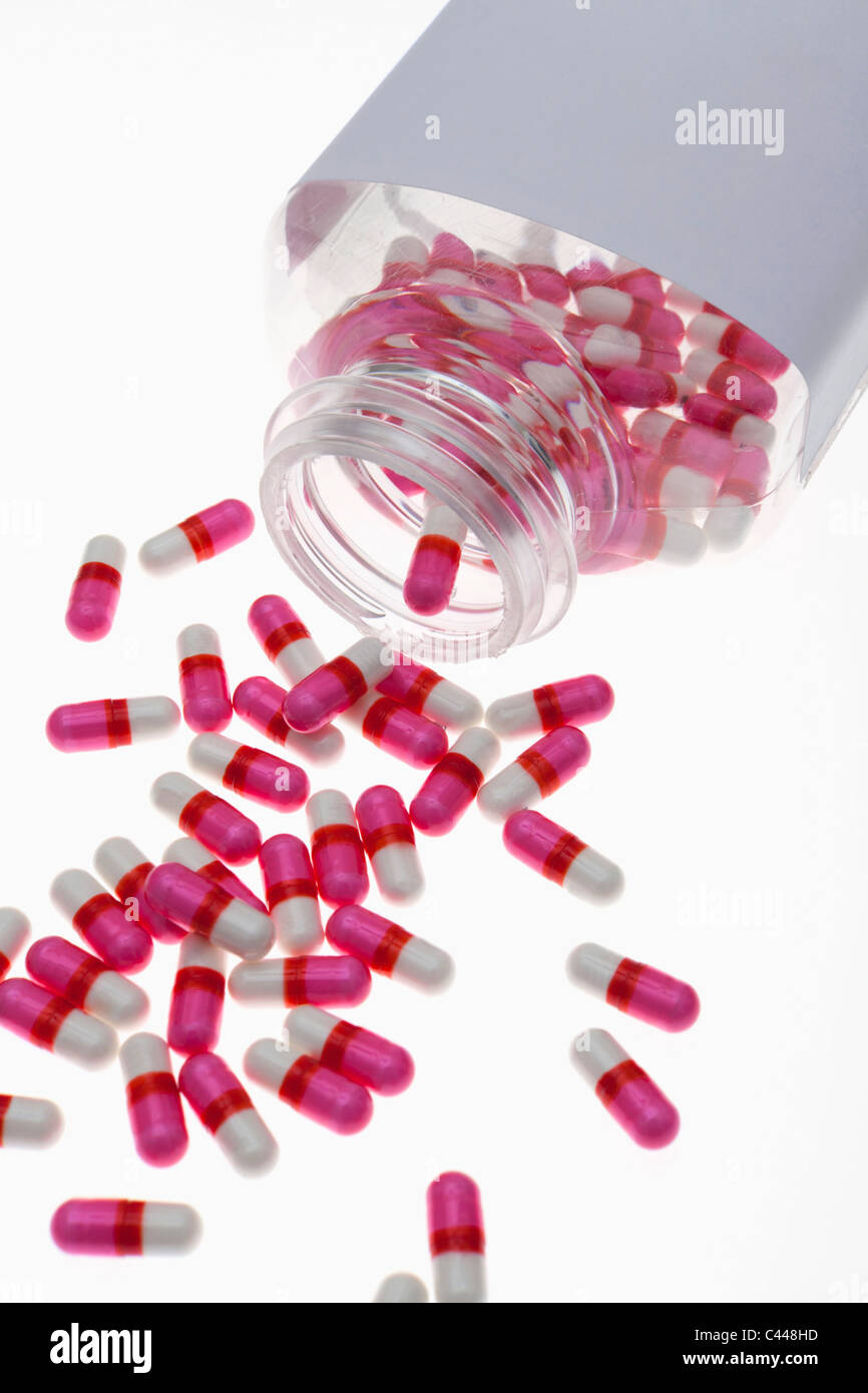 Capsules spilling from a pill bottle Stock Photo - Alamy