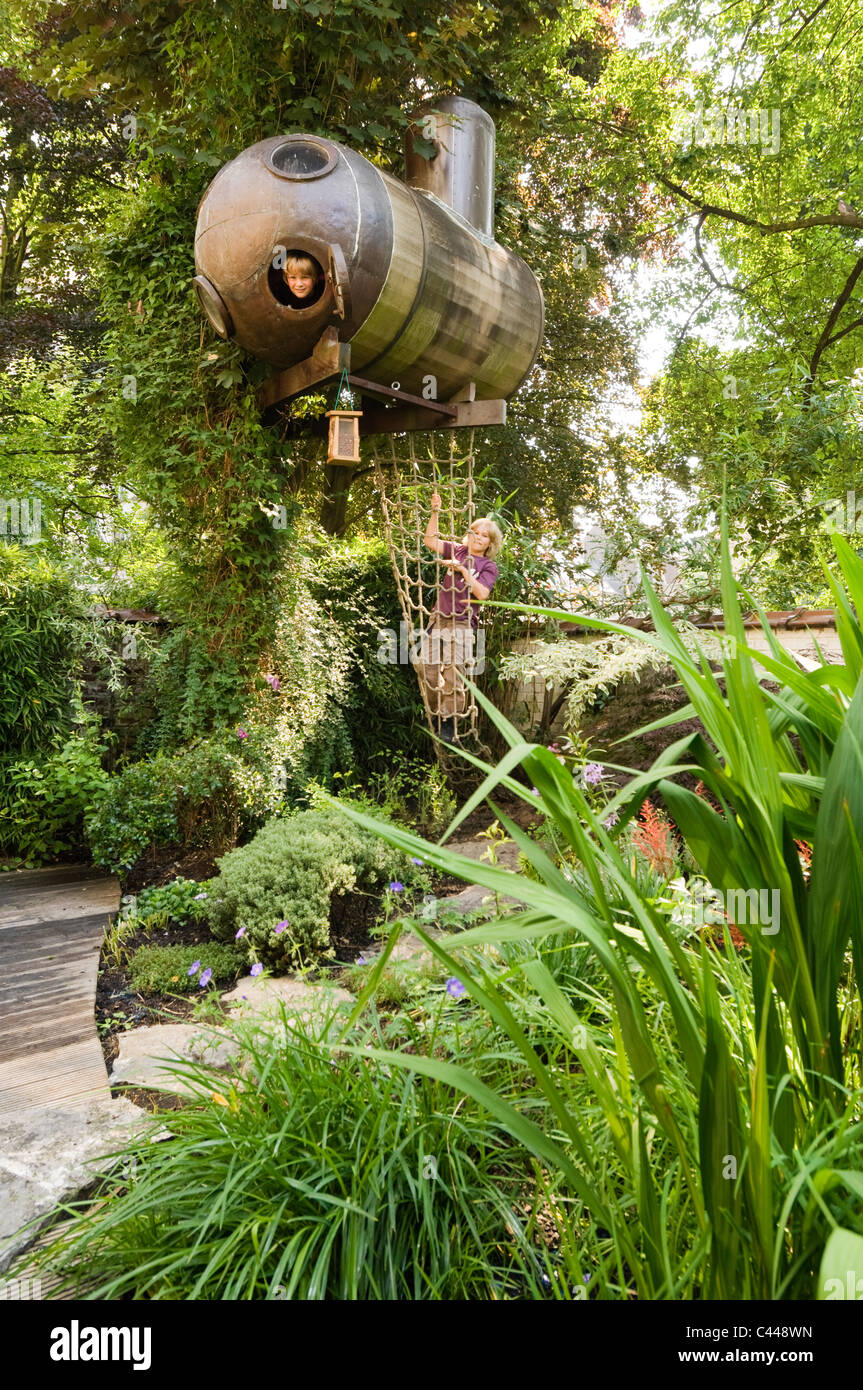 Submarine tree house with net in garden with grasses and decking Stock ...