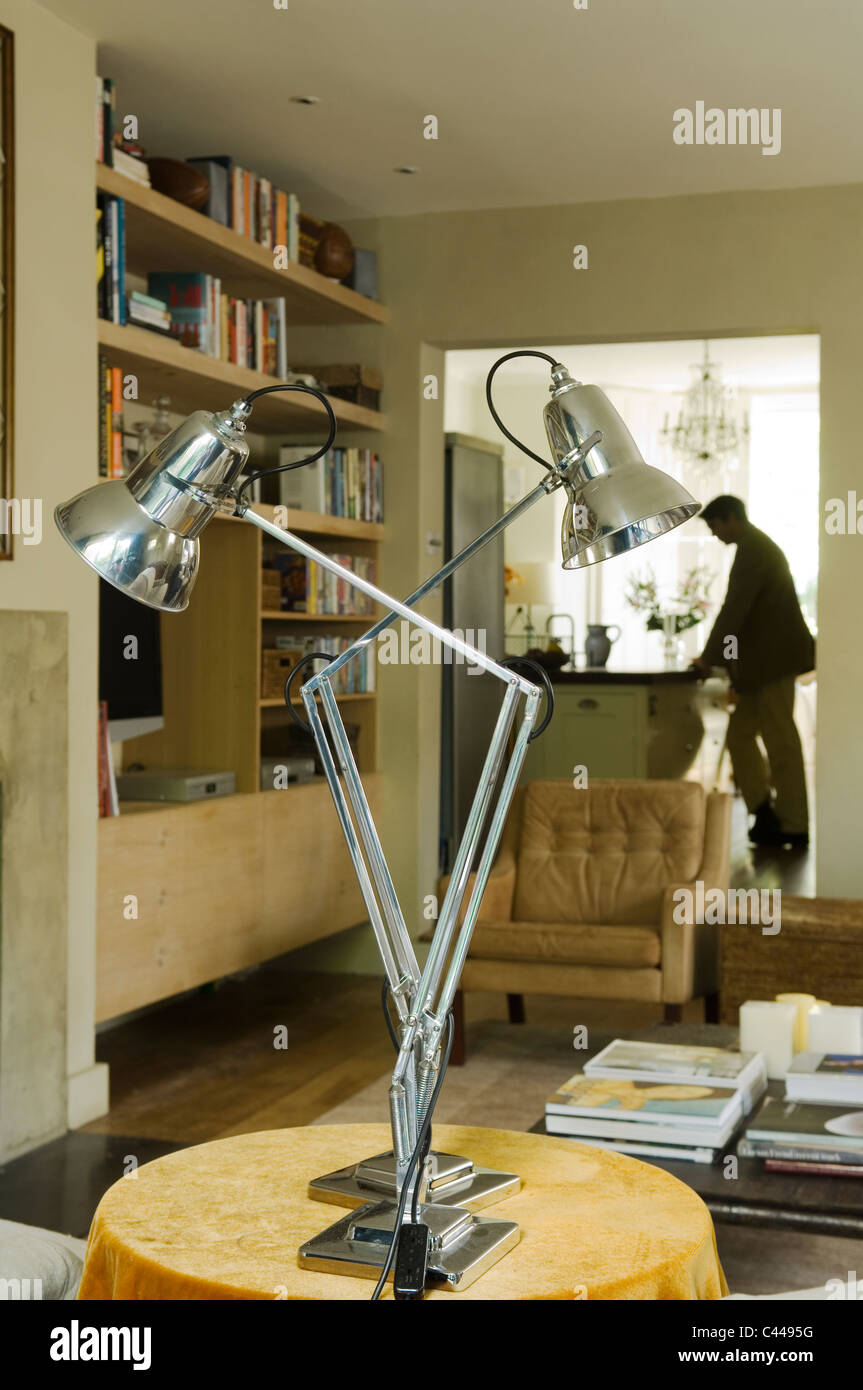 Two anglepoise lamps on a circular table in living room with book ...