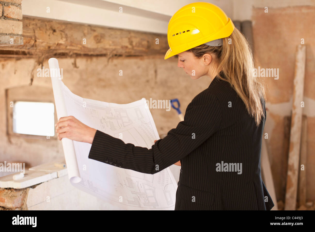 An architect reviewing blueprints at a building site Stock Photo - Alamy