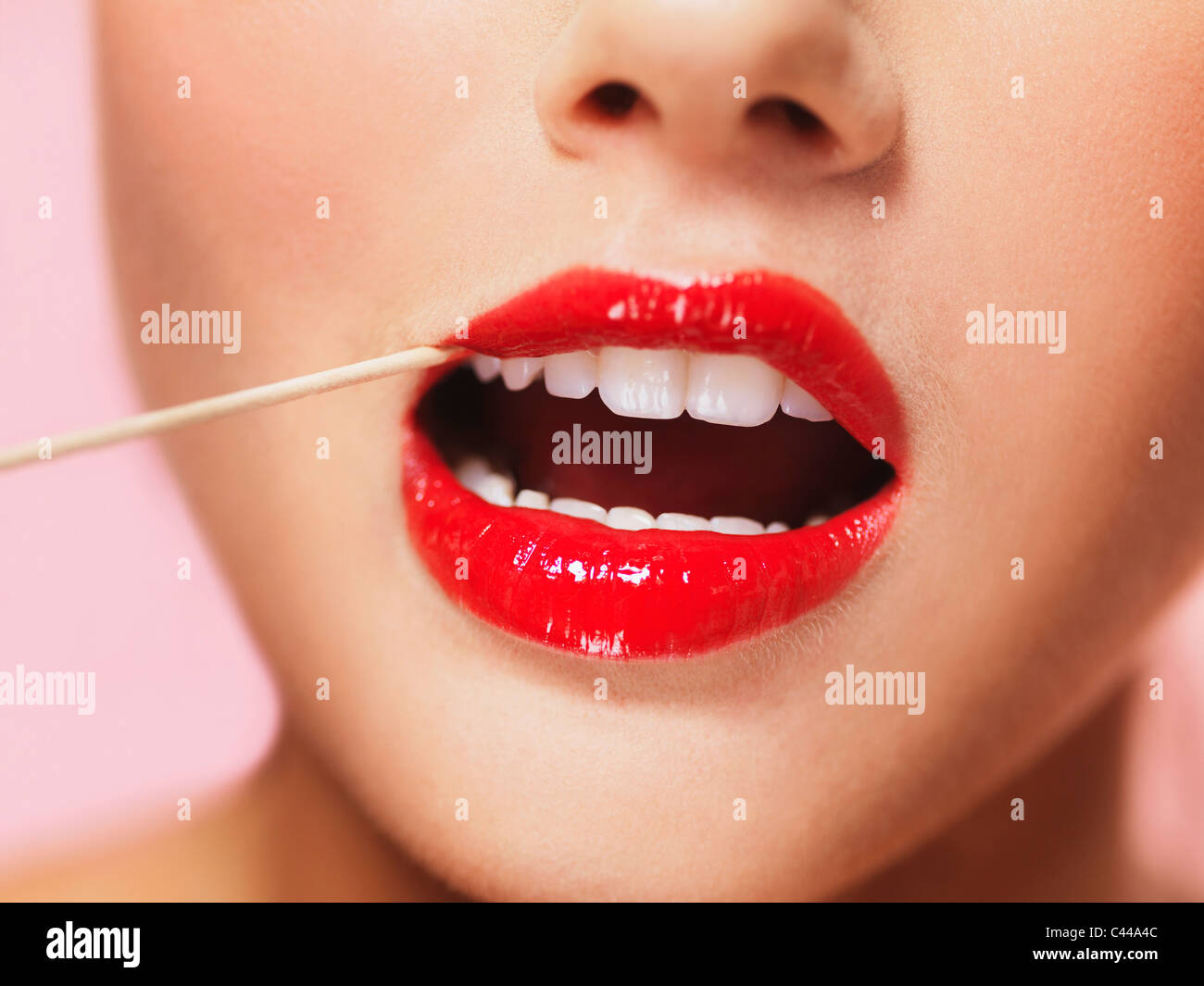 A woman with bright red lipstick on using a toothpick Stock Photo - Alamy