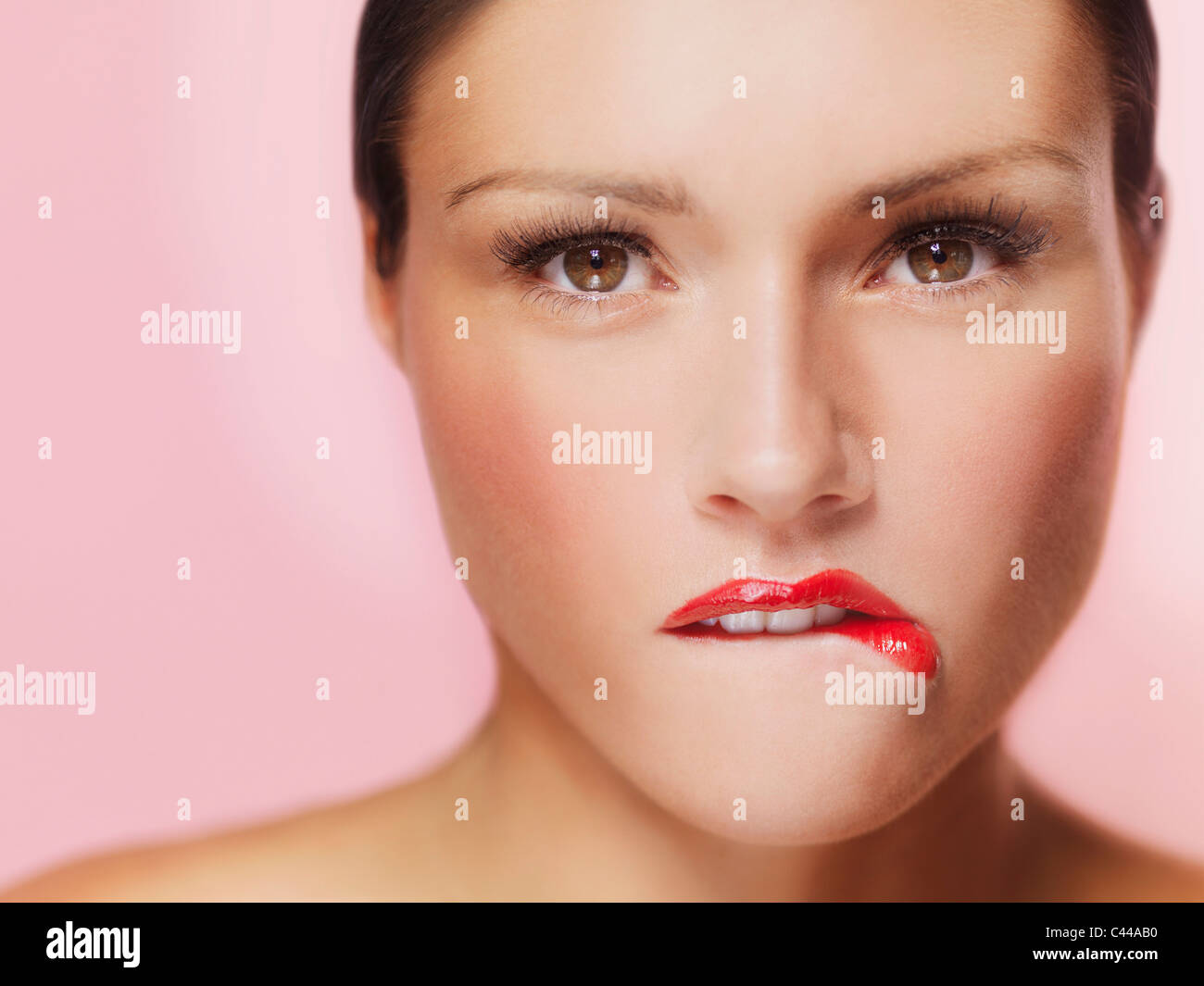 A beautiful woman biting her red painted lips Stock Photo - Alamy