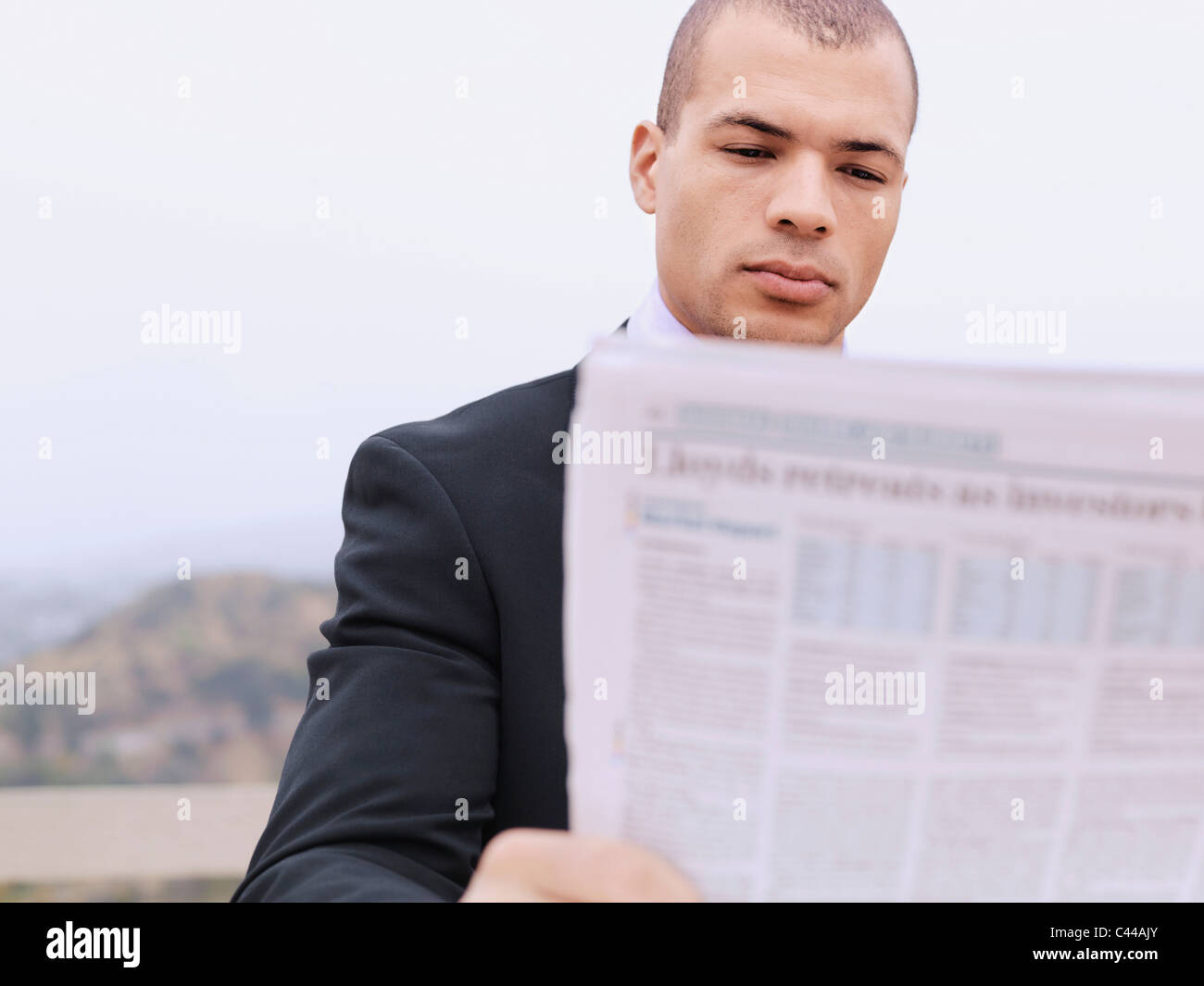 A businessman on a break reading a newspaper outdoors Stock Photo - Alamy