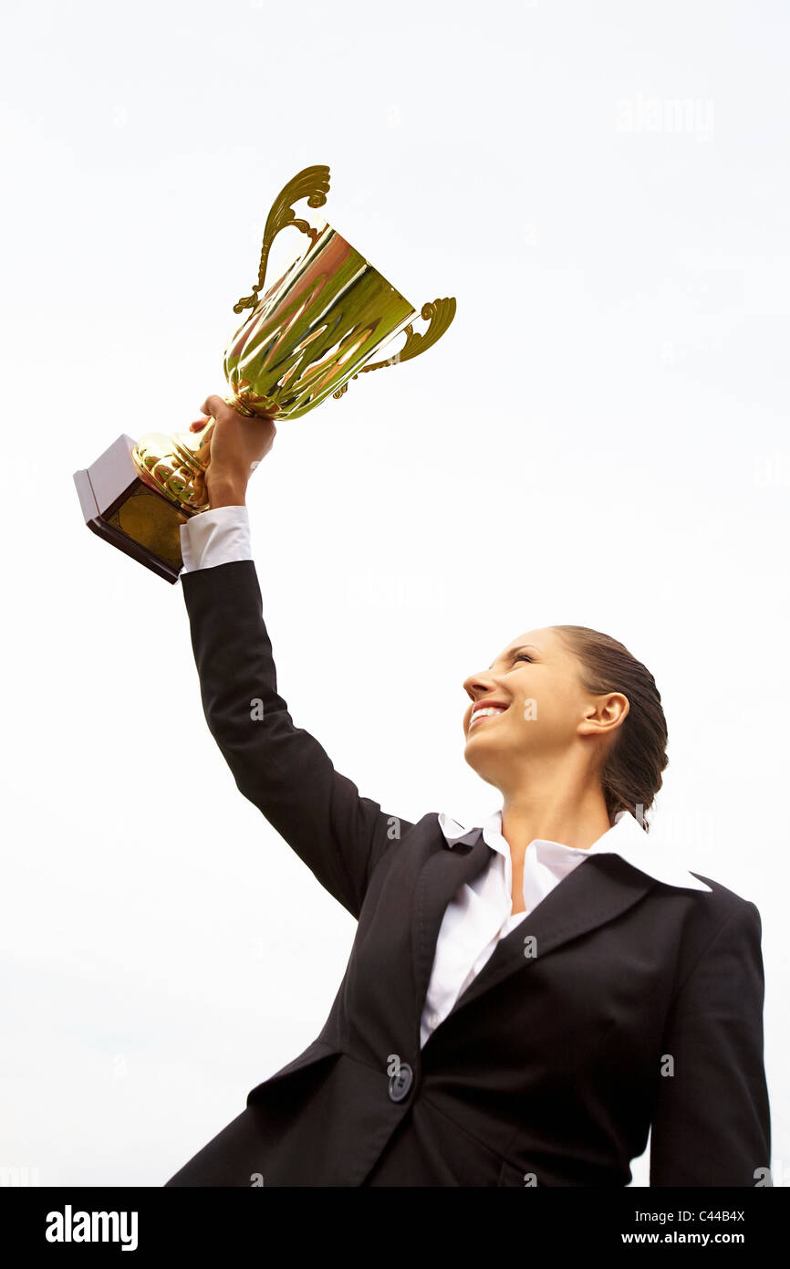 Portrait of happy businesswoman raising championship cup Stock Photo ...