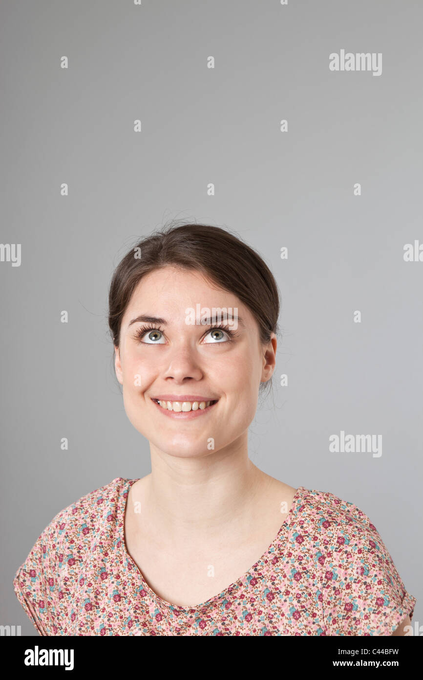A woman looking up excitedly, portrait Stock Photo - Alamy