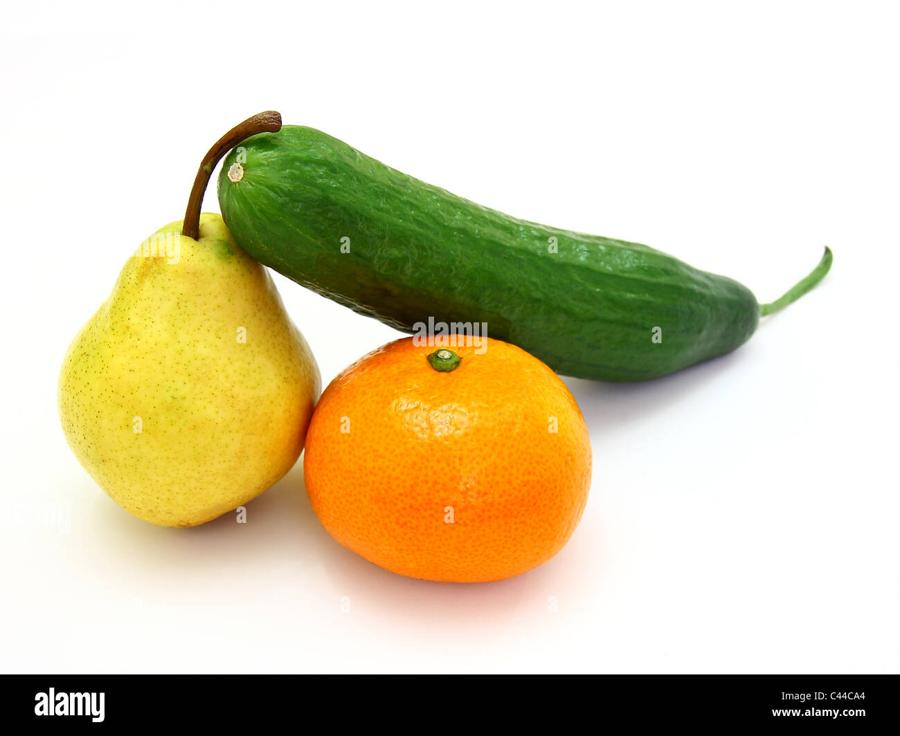 Fresh green cucumber with a tangerine and a pear lie on a white ...