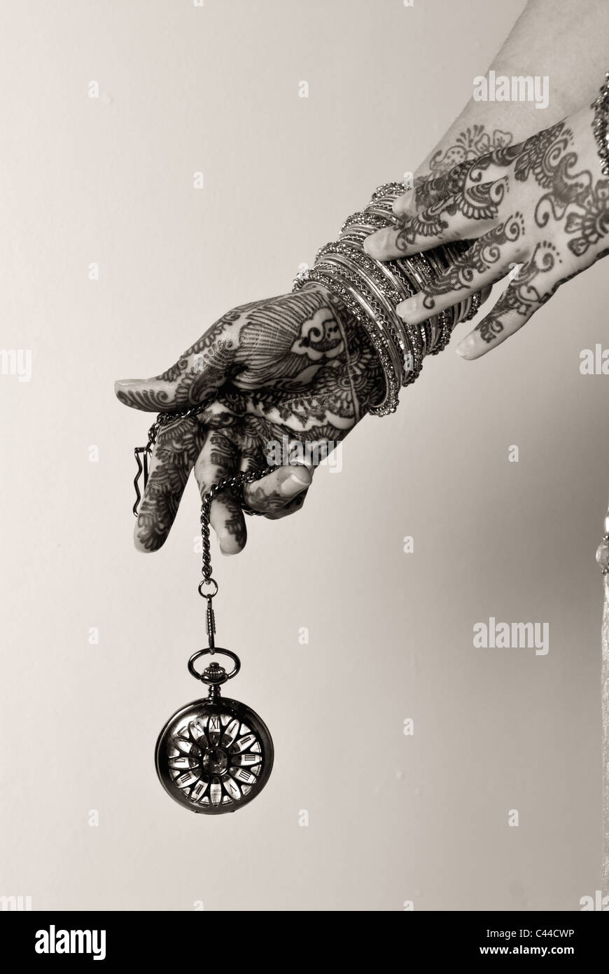 Black/white image of the hands holding the clock locket, showing the ...