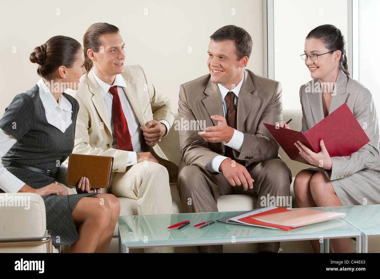 Portrait of business people sitting next to each other and ...