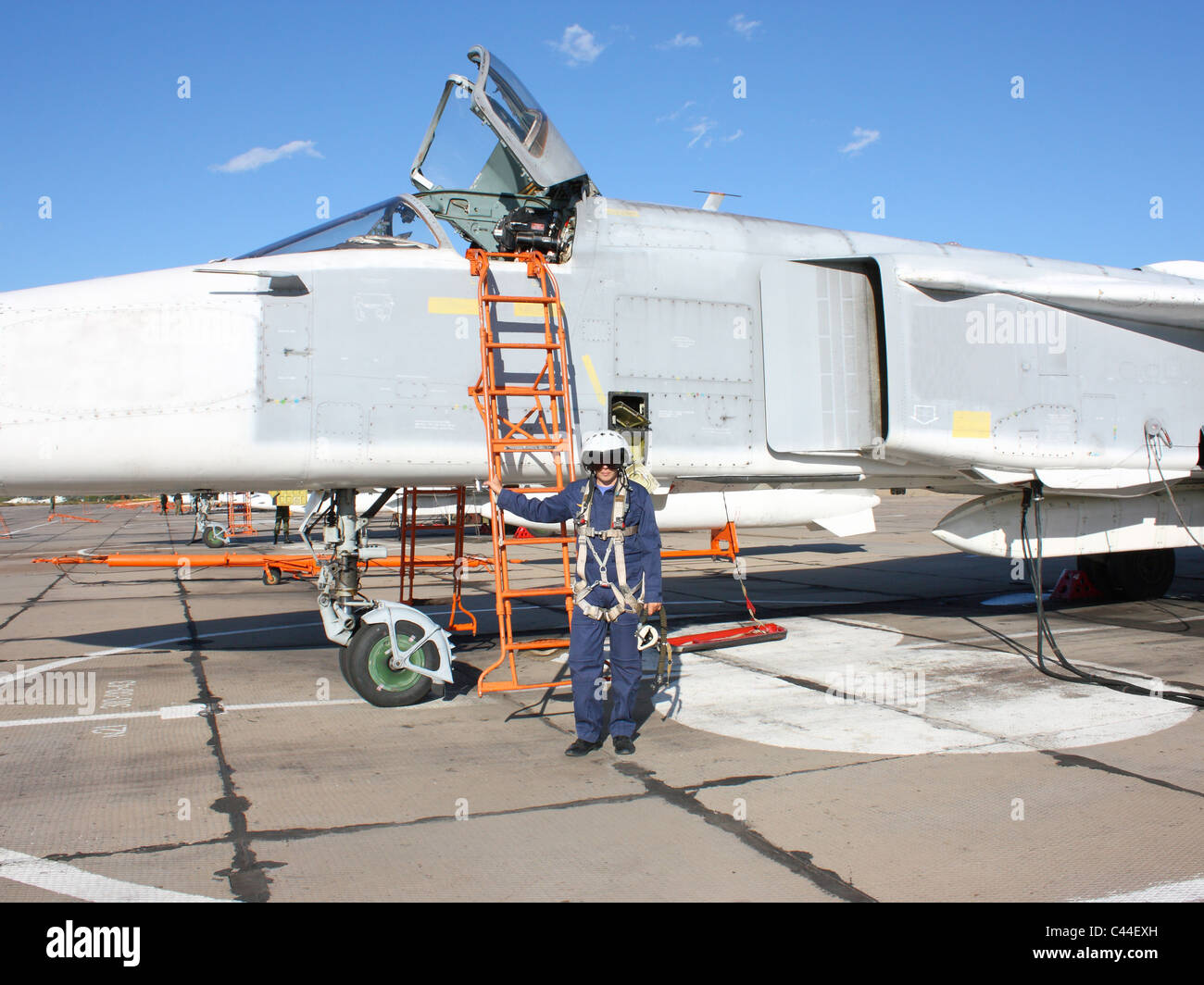 The military pilot in the plane in a helmet in dark blue overalls ...