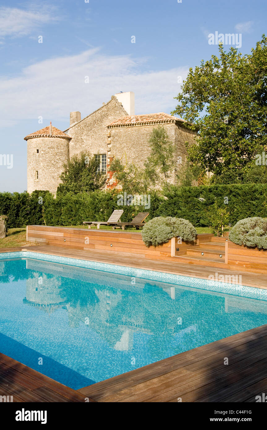 Exterior facade of French chateau and swimming pool and wooden decking ...