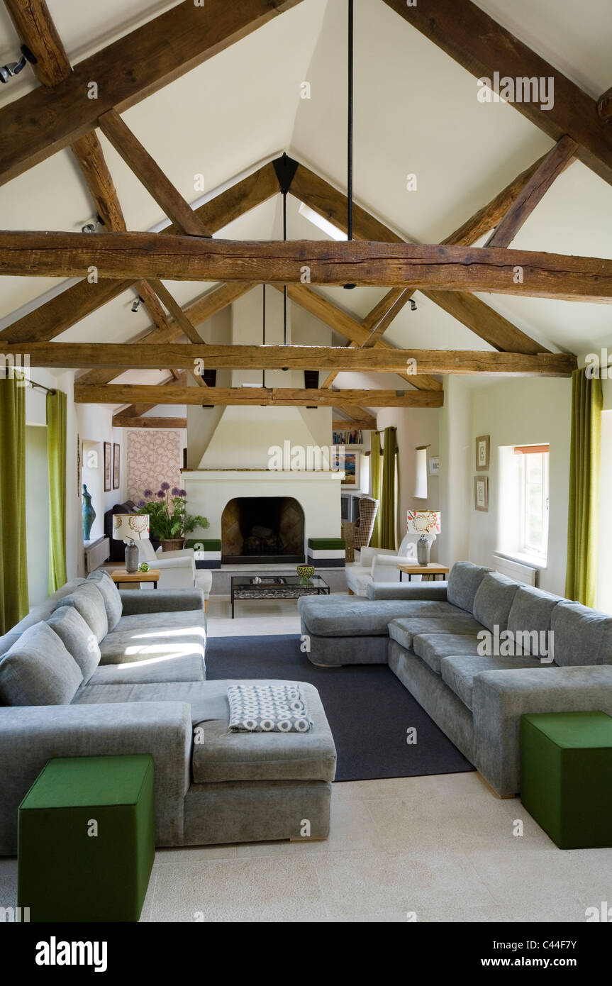 Open plan barn conversion with beamed ceilings, grey sofas and large ...