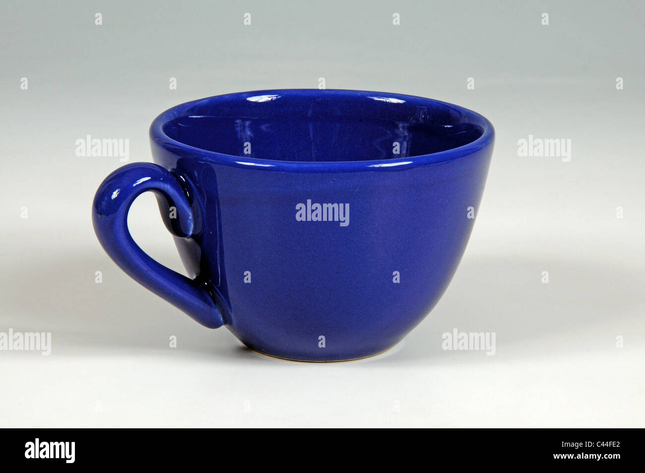 Blue teacup against a grey background Stock Photo - Alamy