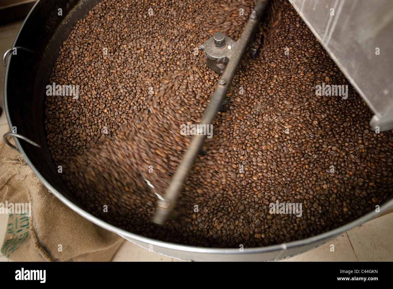 The arms of a coffee roasting machine turn to help the beans roast ...