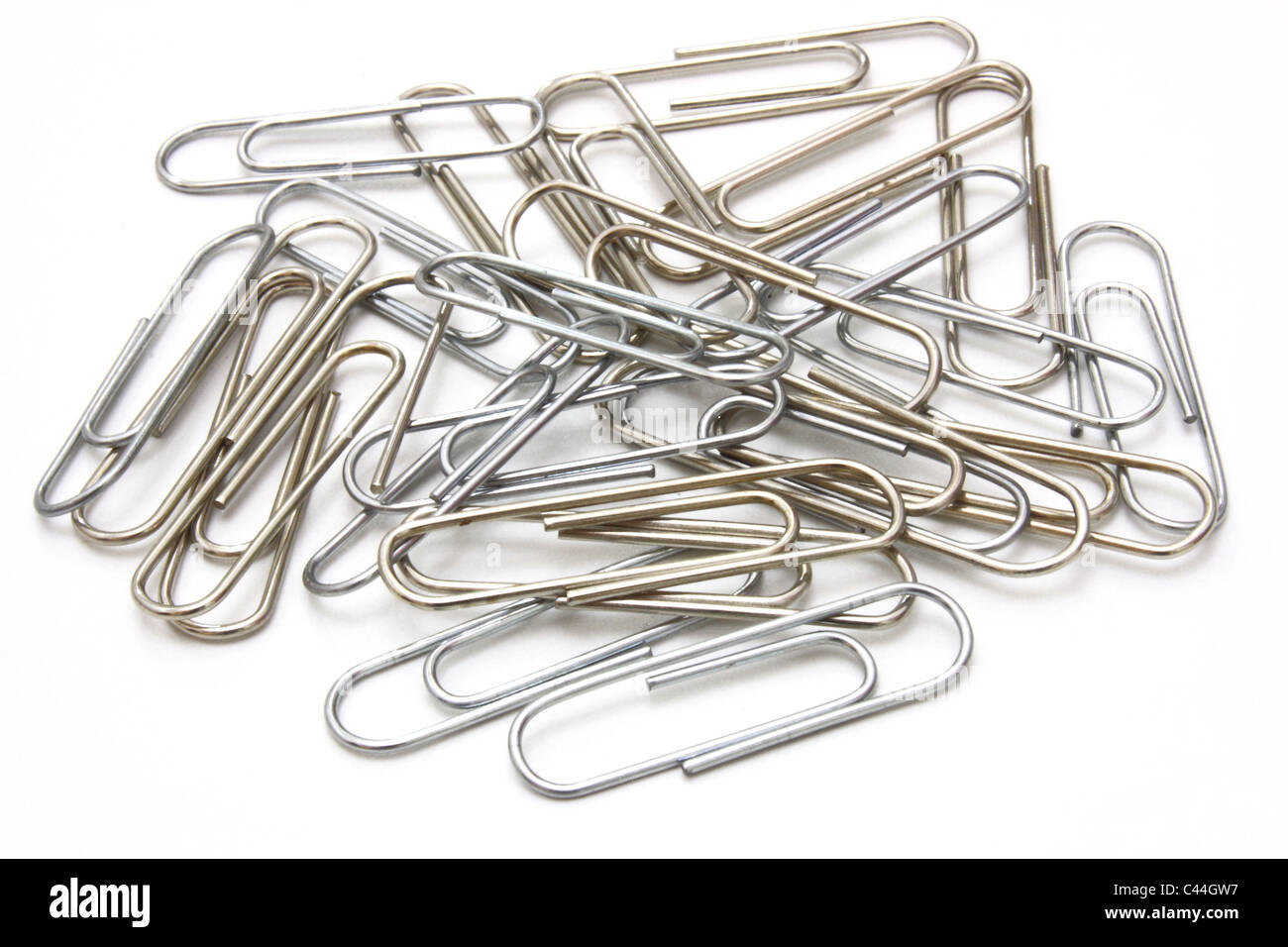 Writing metal paper clips lie in bulk on a white background of a paper ...