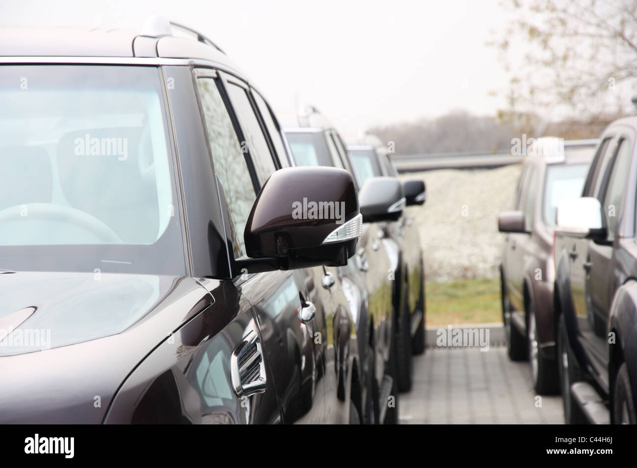 Group of cars stand in one number of dark color Stock Photo - Alamy