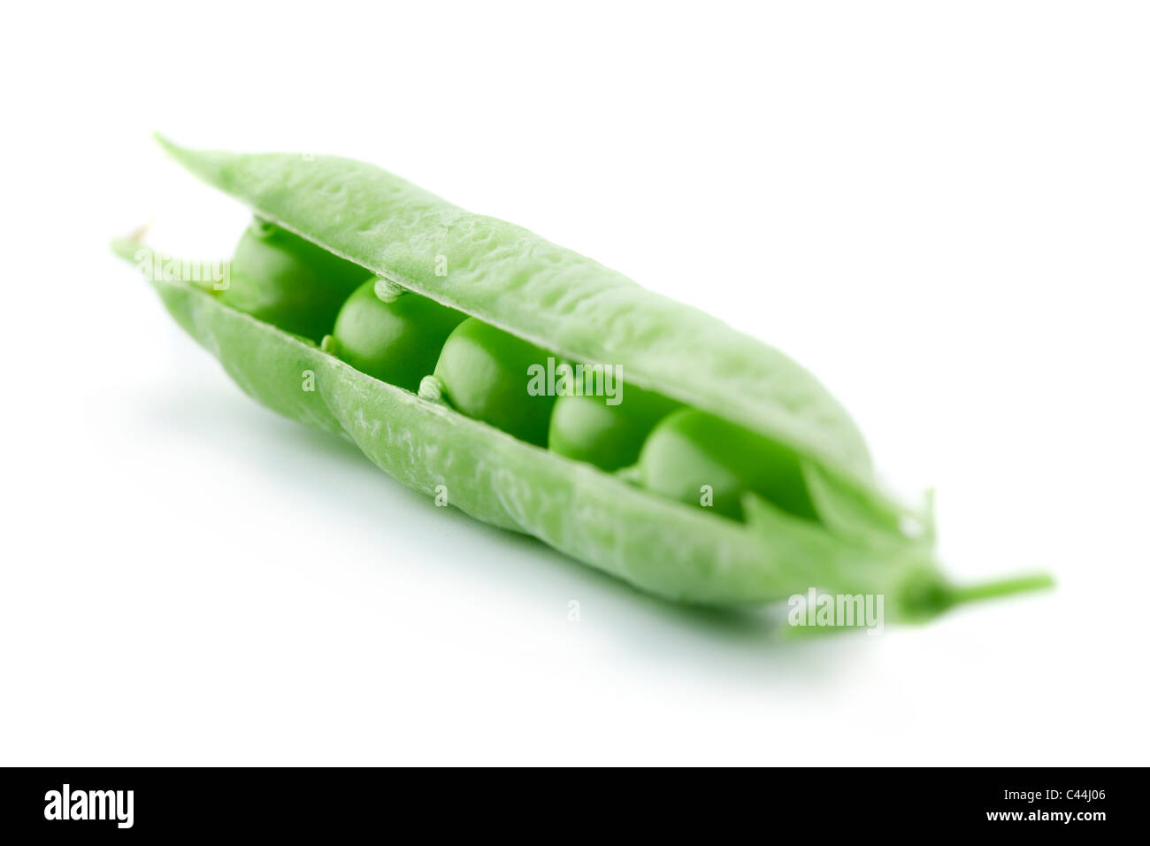 A pea pod revealing peas against white background Stock Photo - Alamy
