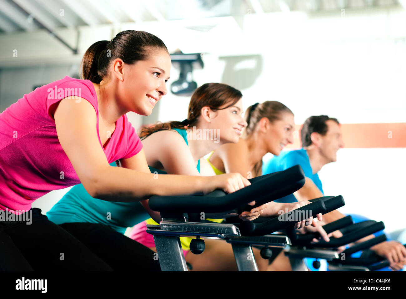Group of four people spinning in the gym, exercising their legs doing ...