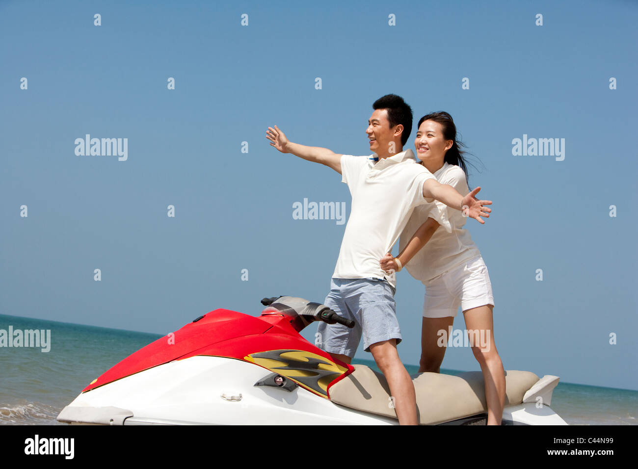 Happy Couple Riding on a Jet Ski Stock Photo - Alamy