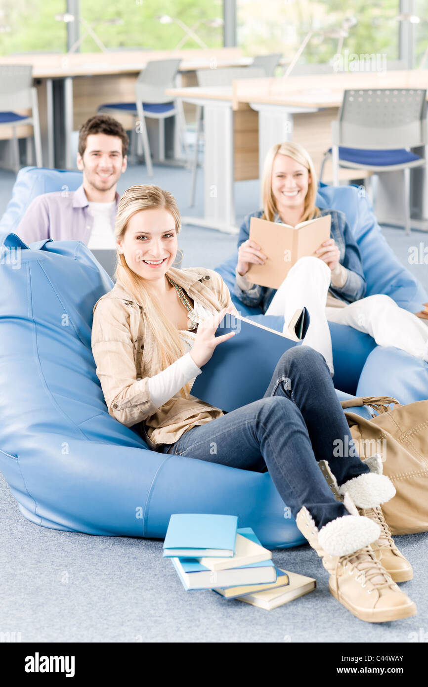 Group of young high-school students relaxing with books and laptop ...