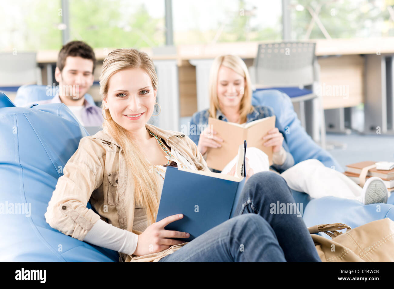 Portrait of high school female student hold book - classmates in ...