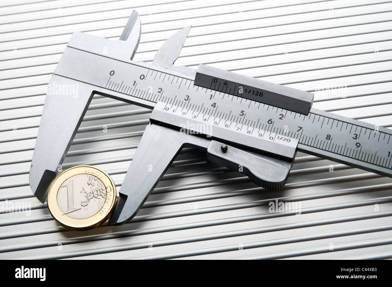 metal gauge measuring a one euro coin on a metal surface Stock Photo ...