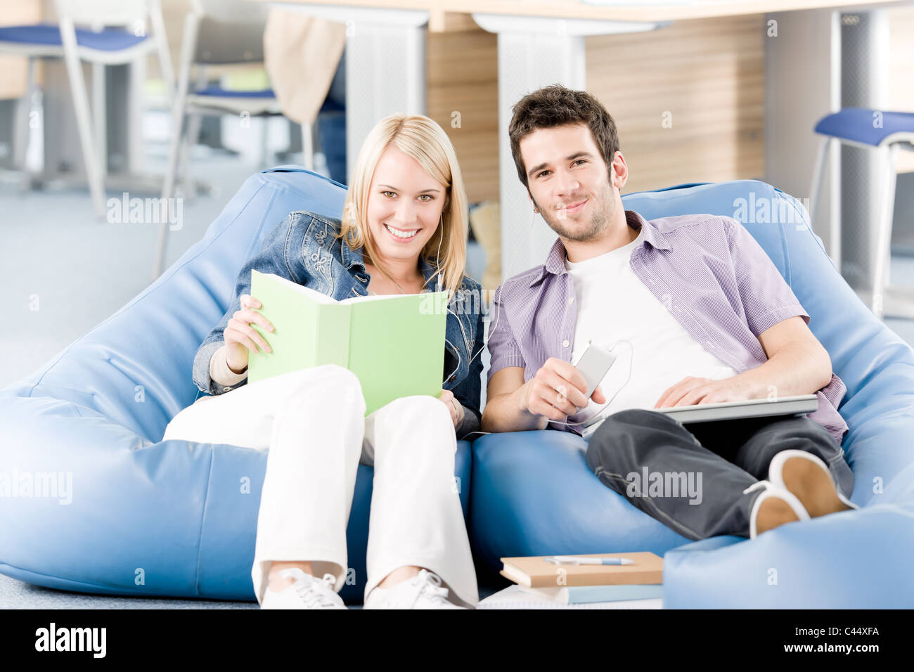 Smiling young high-school students reading book listen music Stock ...