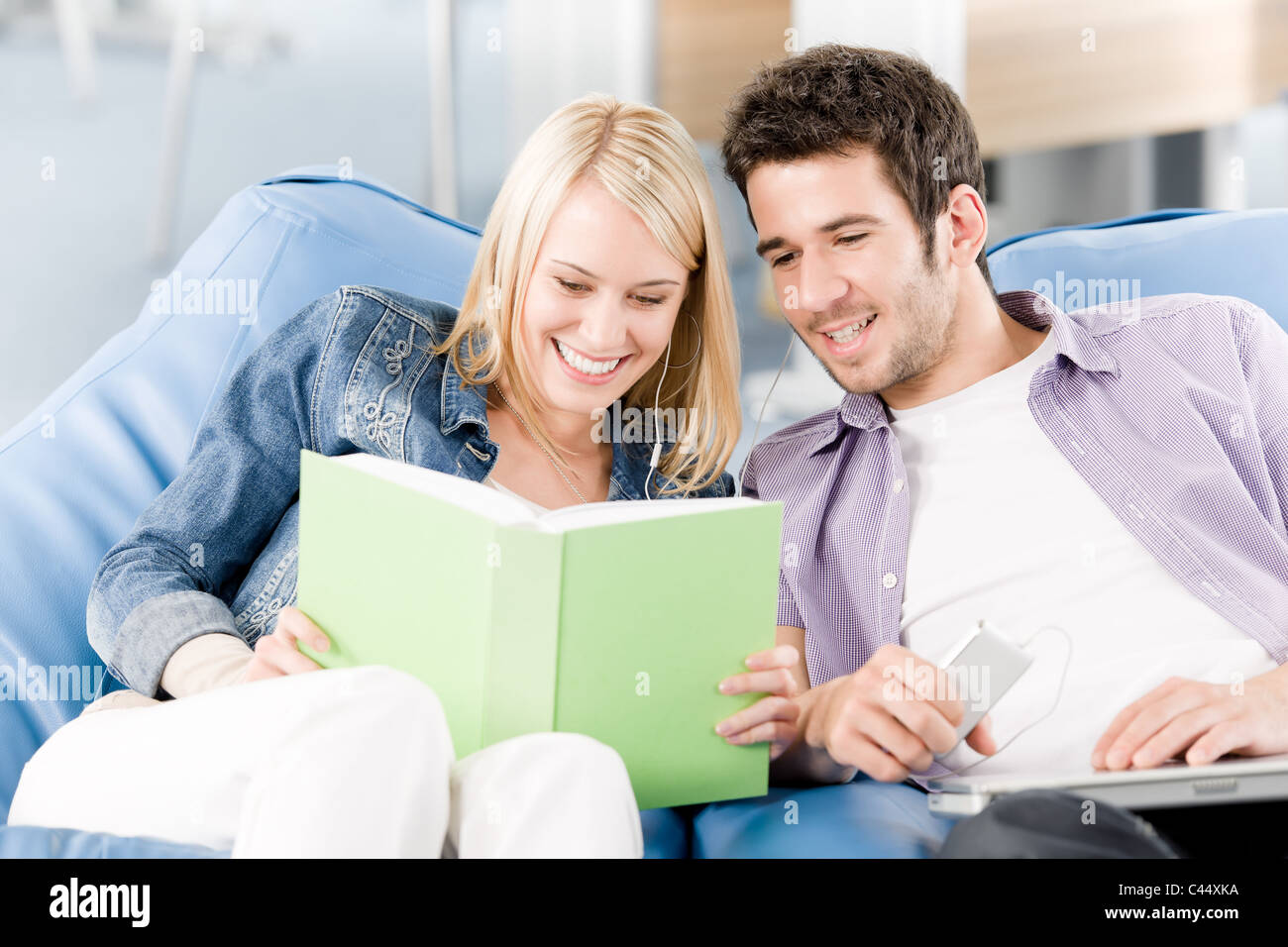 Smiling young high-school students reading book listen music Stock ...