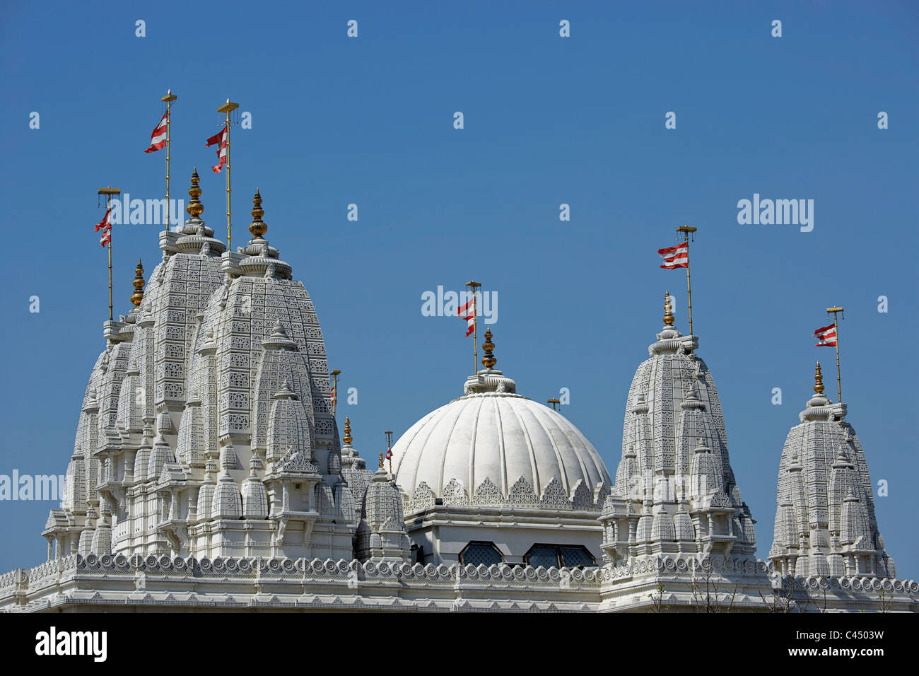 England, London, BAPS Shri Swaminarayan Mandir, temple dome with flags ...
