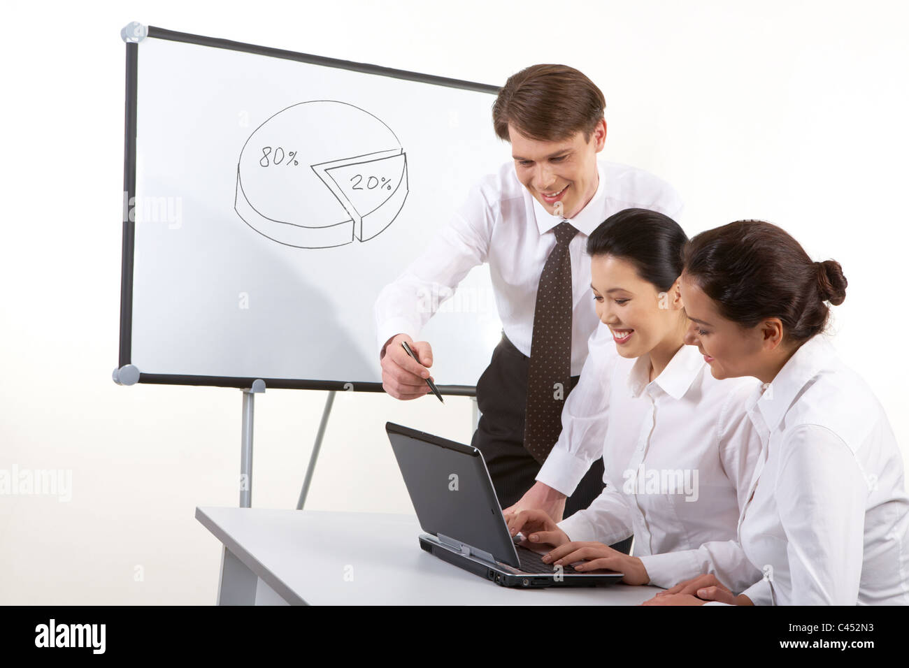 Two smiling business ladies looking at laptop screen while their ...