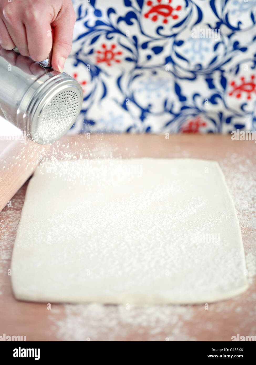 Woman sprinkling flour on dough, close-up Stock Photo - Alamy