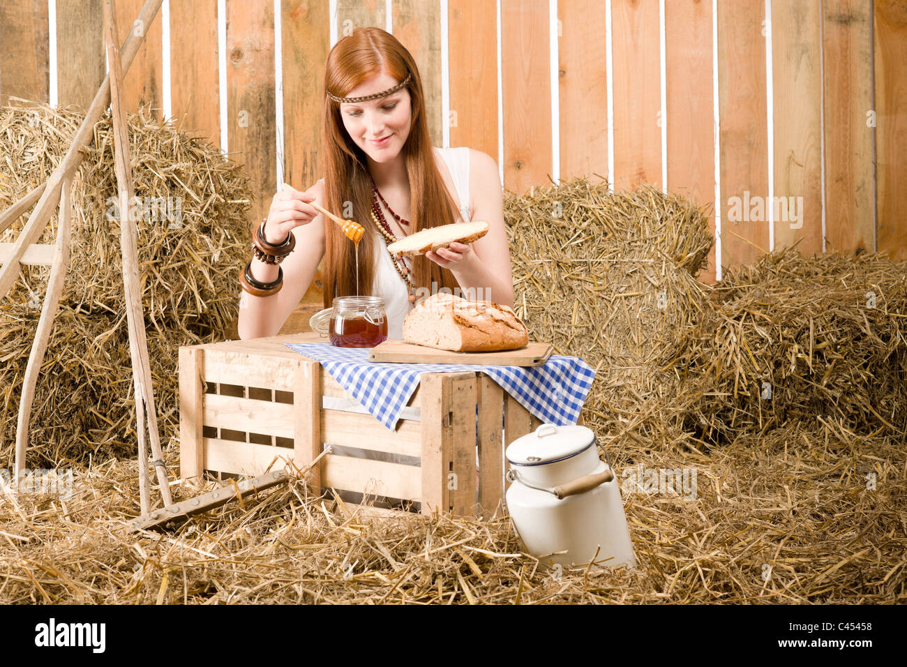 Redhead young hippie woman have breakfast on hay in barn Stock Photo ...