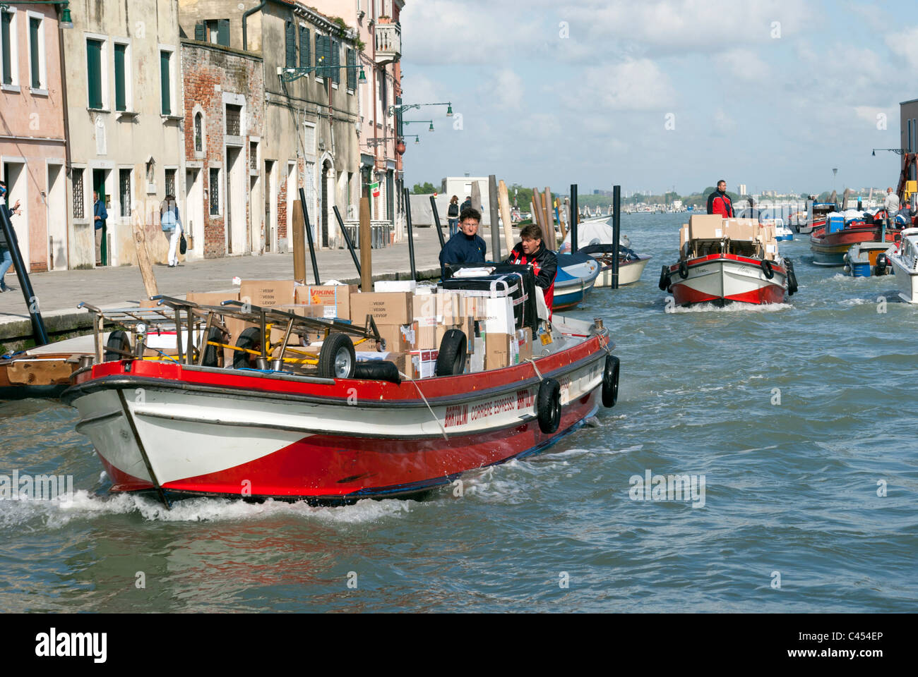 Workboats navigate a busy canal in Venice, Italy Stock Photo - Alamy