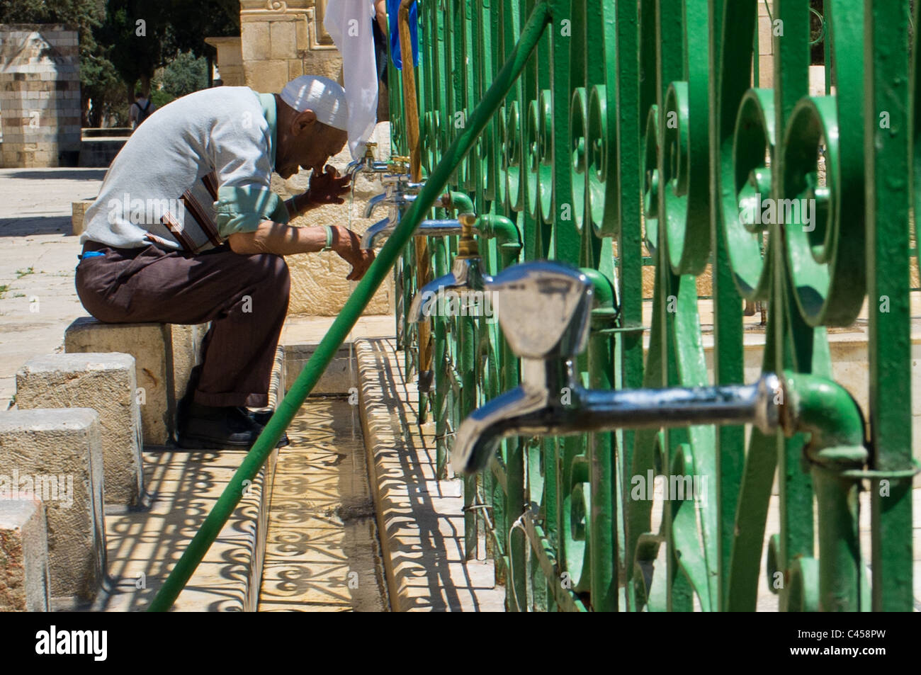 Elderly Muslim observes purification customs before prayer at the Al ...