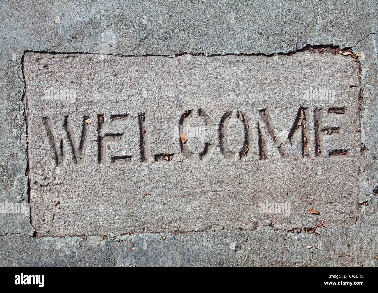outline of welcome mat set in concrete Stock Photo - Alamy