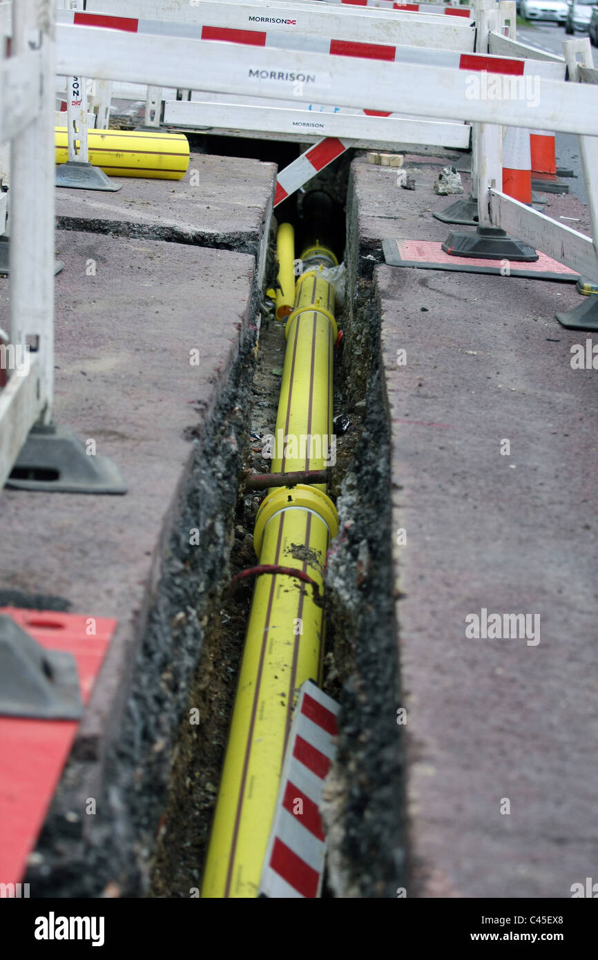 A trench in roadworks showing part of a new gas pipe that has jut been ...