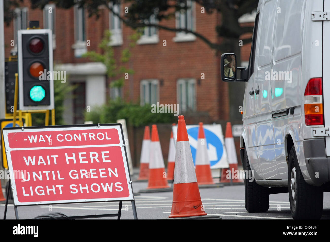 A white van traveling passed a set of roadworks controlled by temporary ...
