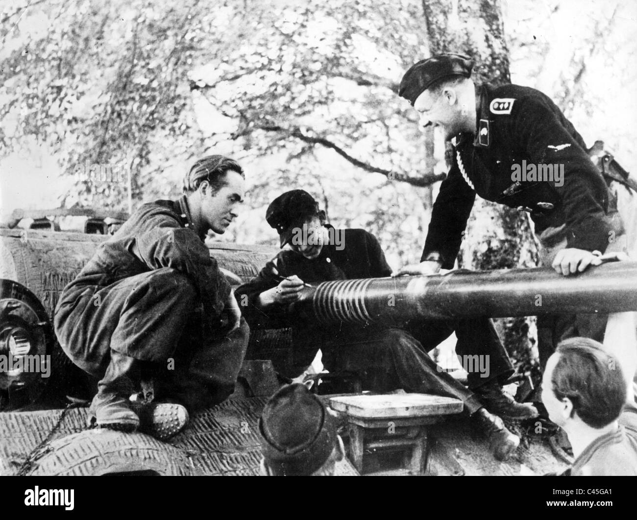 German soldiers paint firing rings on the tube of their tanks on the ...