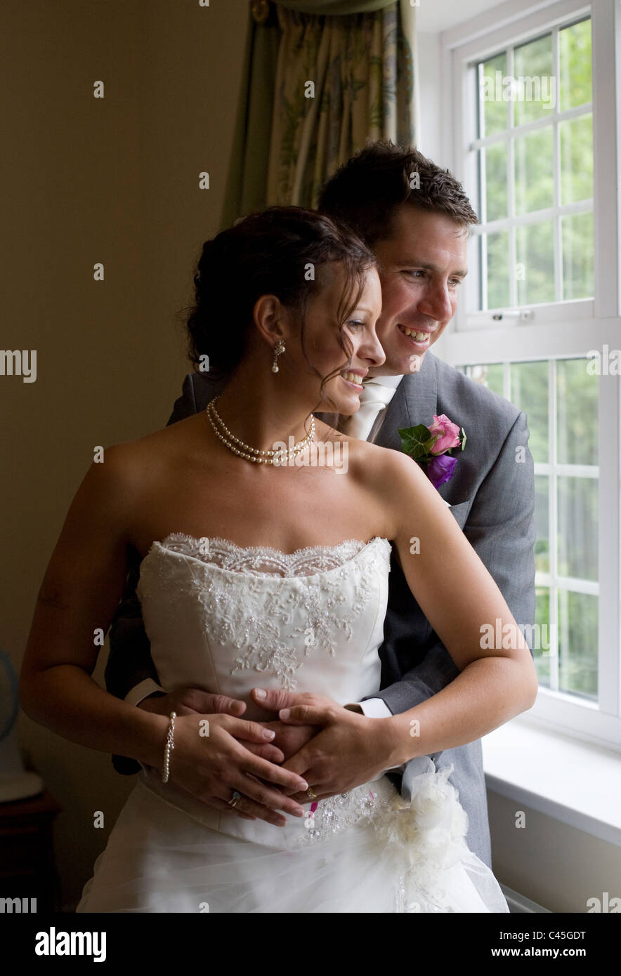 Wedding couple standing by the window of their wedding suite Stock ...